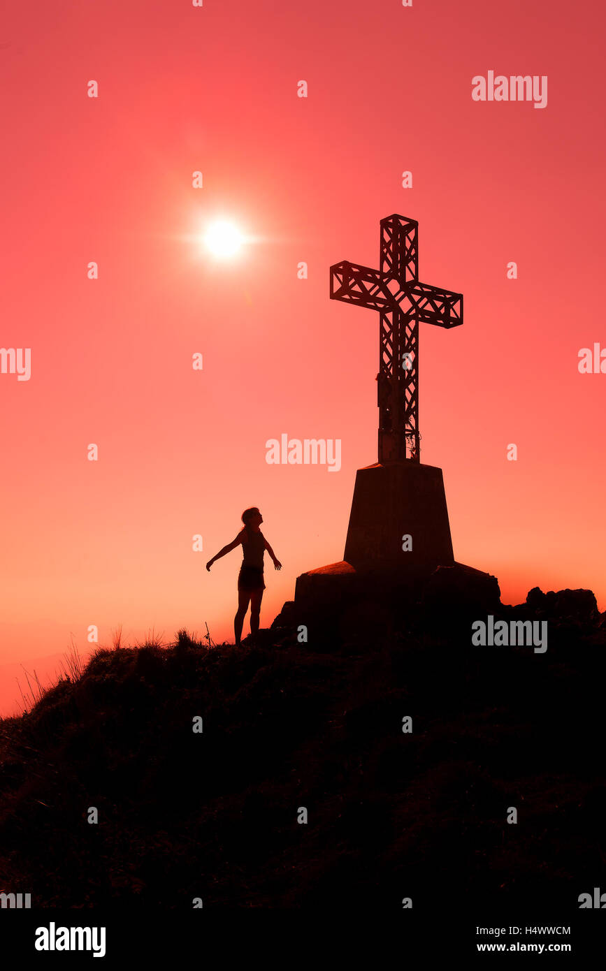 Cross on top of a mountain with open arms woman in prayer Stock Photo ...