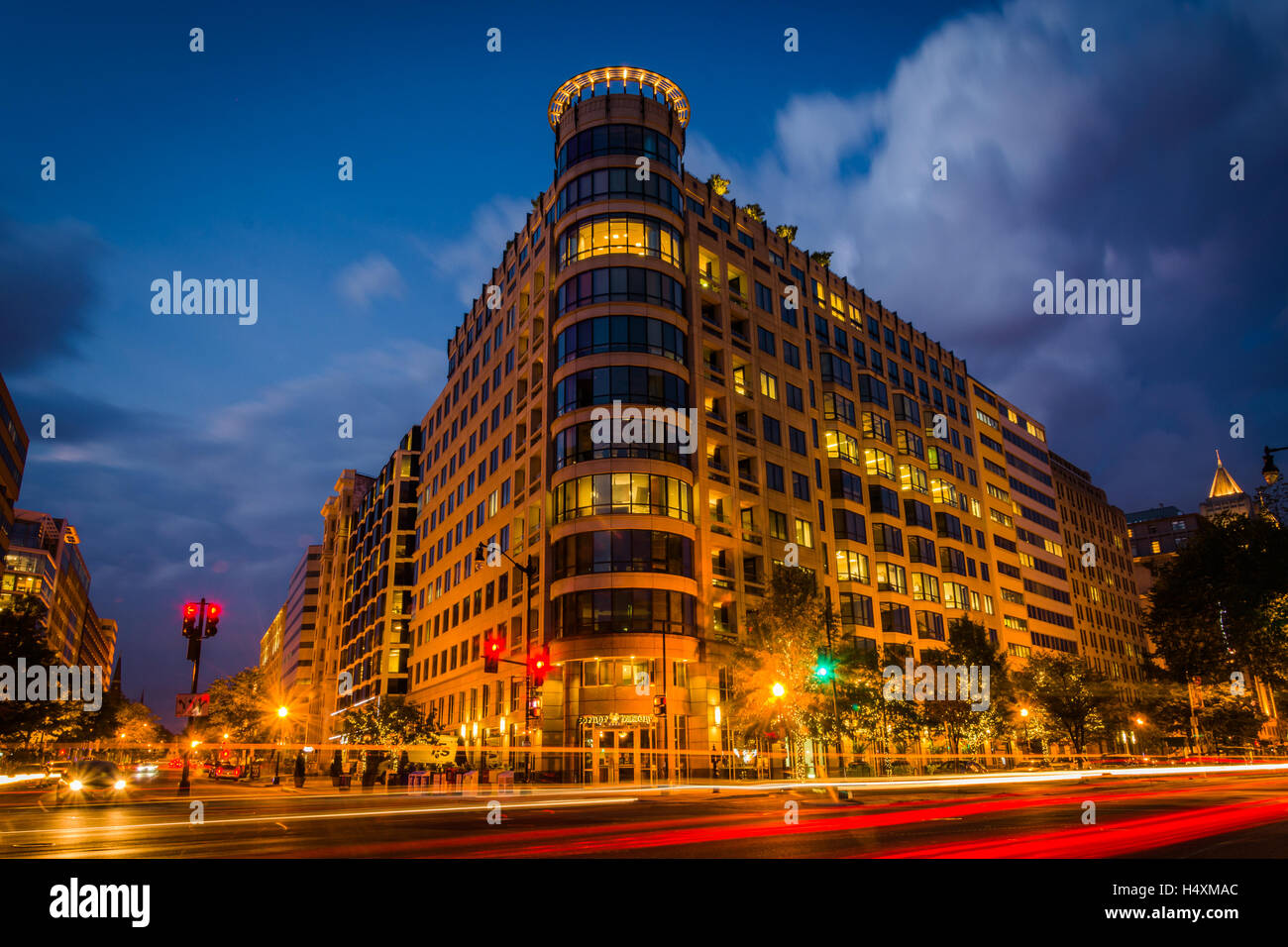 Long exposure of traffic on K Street and a modern building at night, in ...
