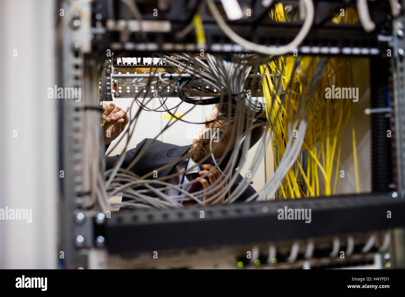 Technician talking on mobile phone while checking cables Stock Photo ...