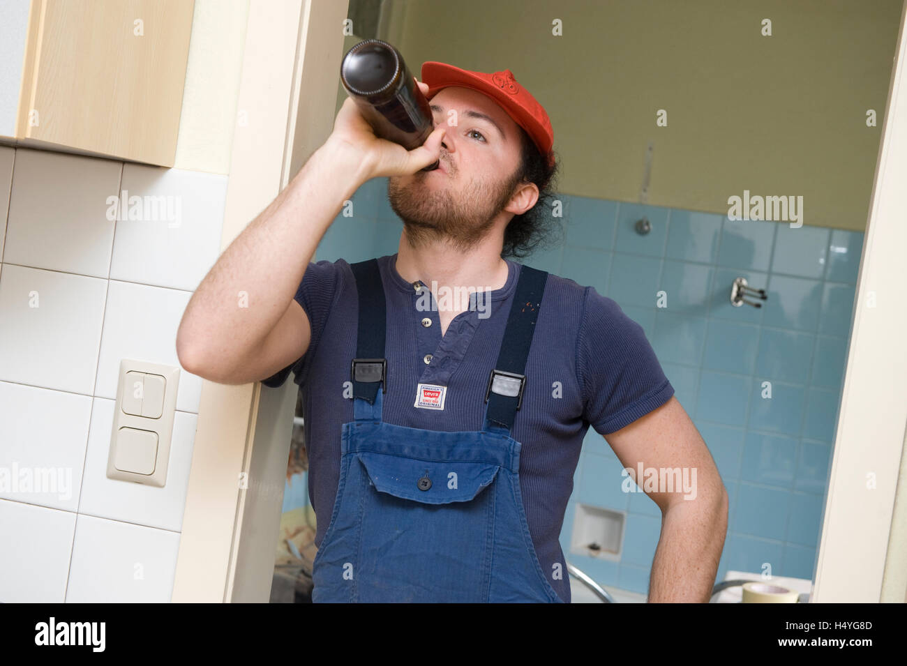 Workman with beer bottle at work Stock Photo - Alamy
