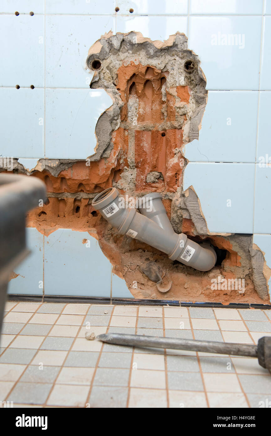 Pried open wall with water pipes Stock Photo - Alamy