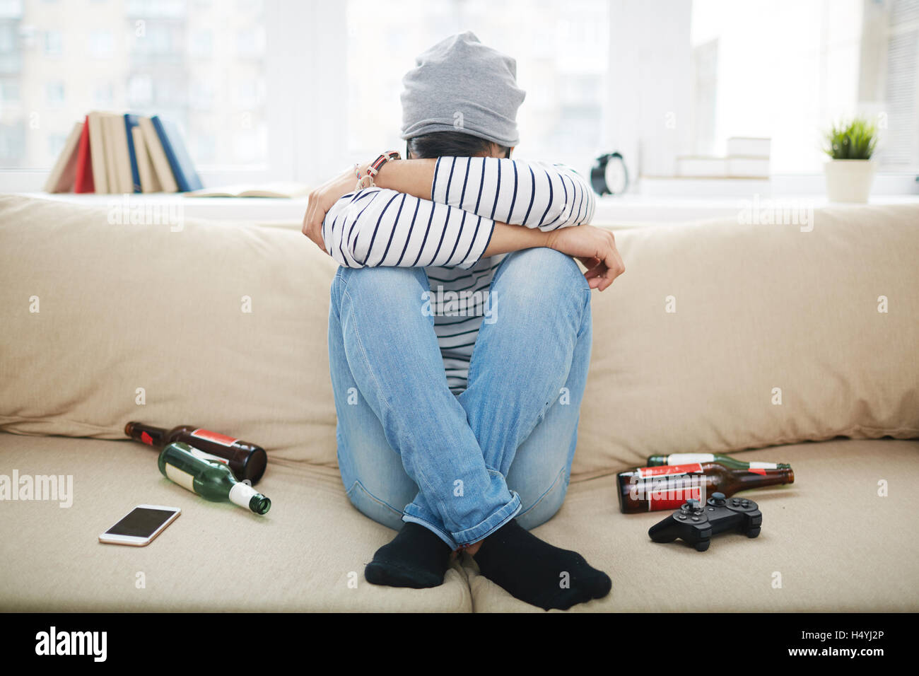 Sad teenager sitting near sofa hi-res stock photography and images - Alamy