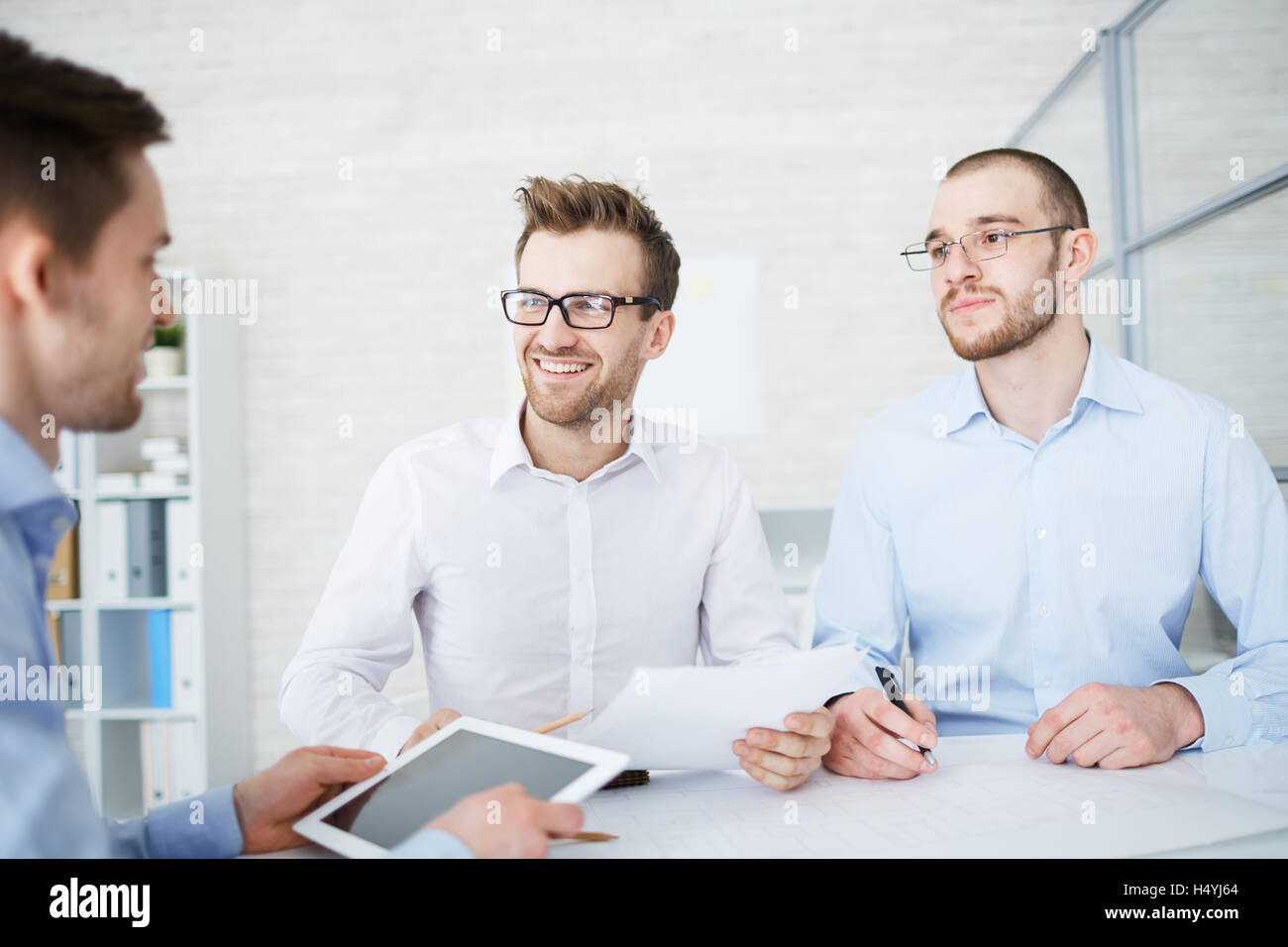 Young engineers listening to ideas of colleague Stock Photo - Alamy