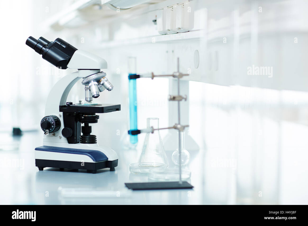 Microscope and chemical glassware in lab Stock Photo - Alamy
