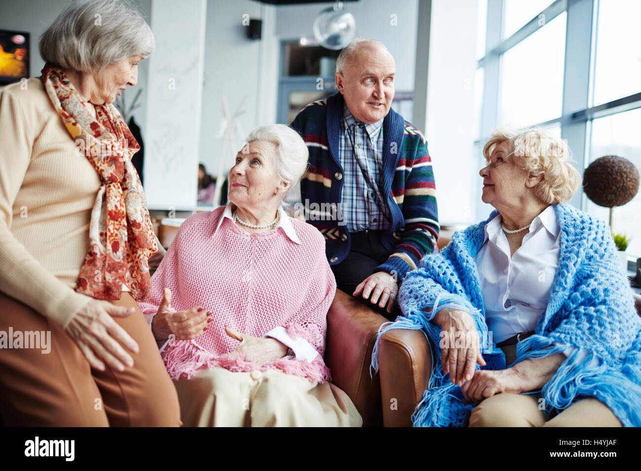 Aged adults having conversation indoors Stock Photo - Alamy