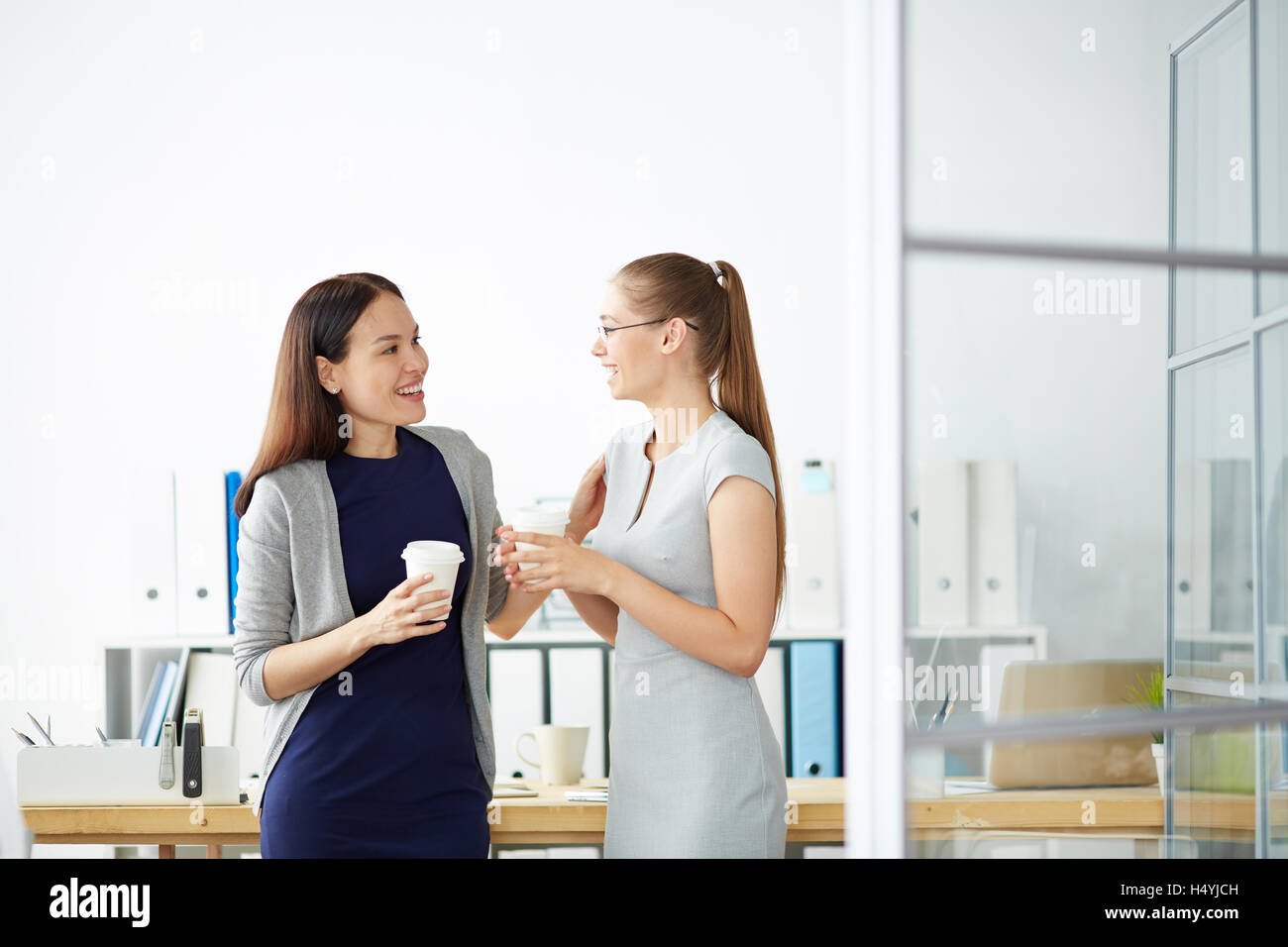 Young managers talking at coffee break in office Stock Photo - Alamy