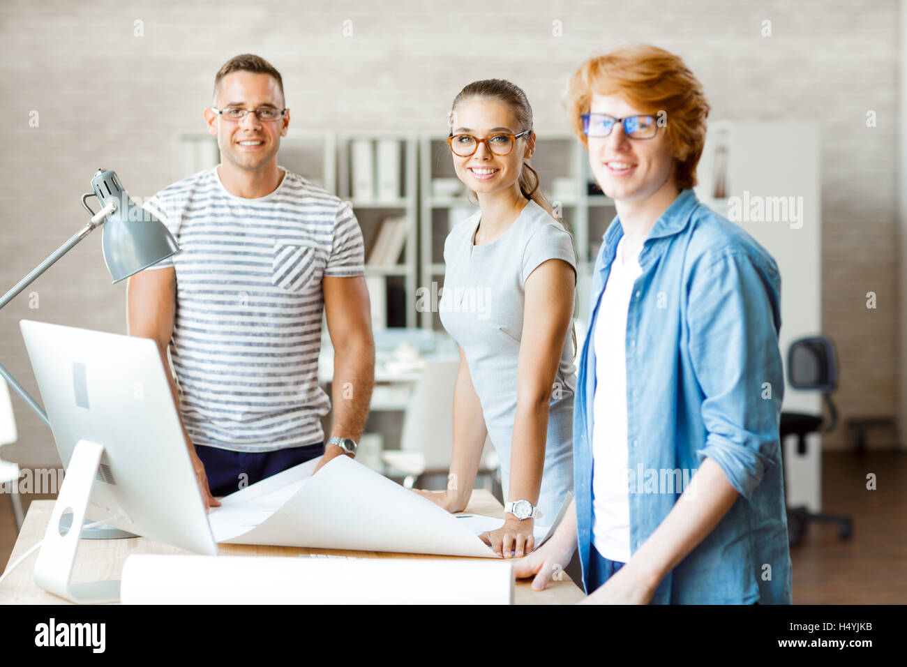 Group of young architects standing by their workplace Stock Photo - Alamy