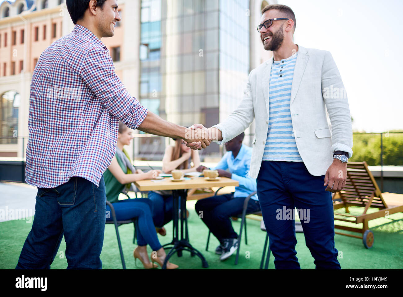 Two young businessmen handshaking outdoors Stock Photo - Alamy