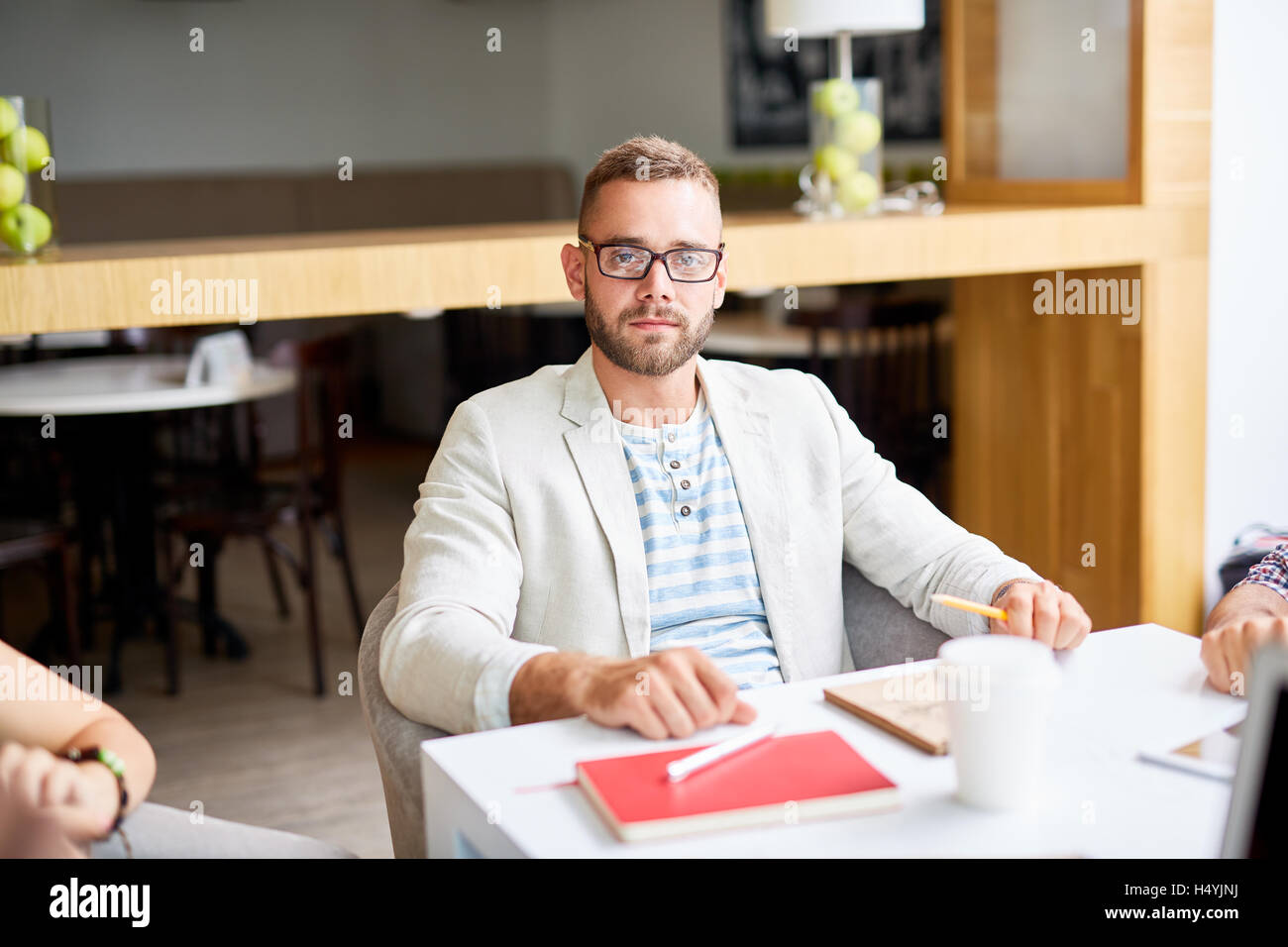 Serious businessman looking at camera at workplace Stock Photo - Alamy