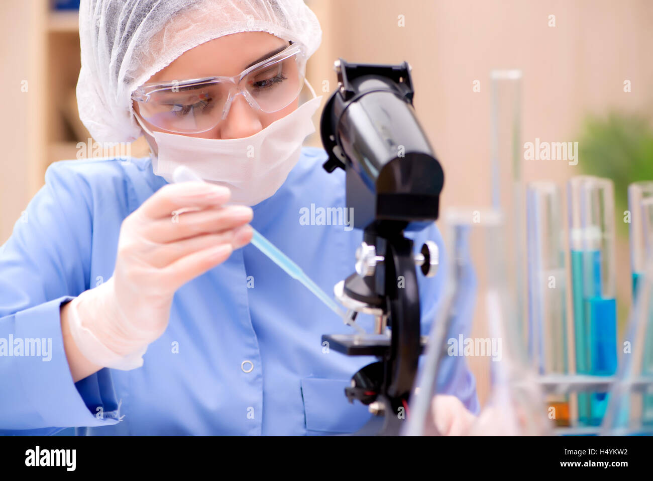 Lab chemist working with microscope and tubes Stock Photo - Alamy
