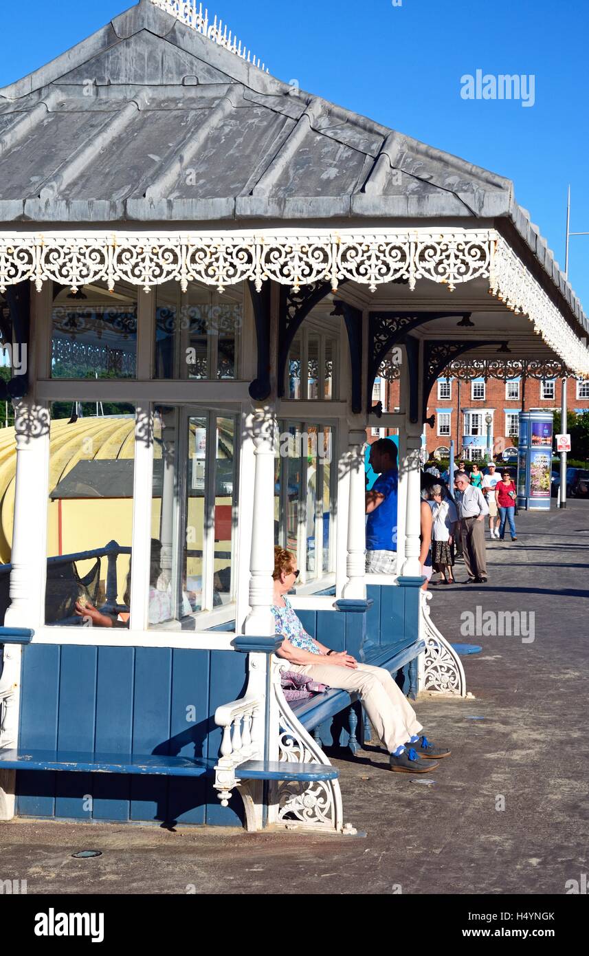 Covered bench along the Esplanade promenade with tourists enjoying the ...