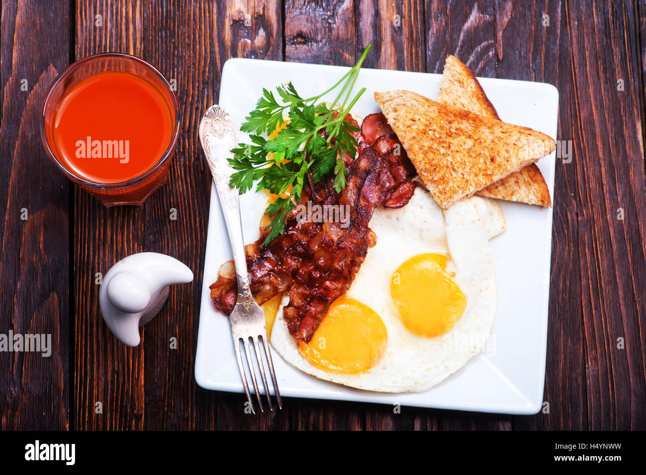 Breakfast on a table, fried bacon and eggs on plate Stock Photo - Alamy