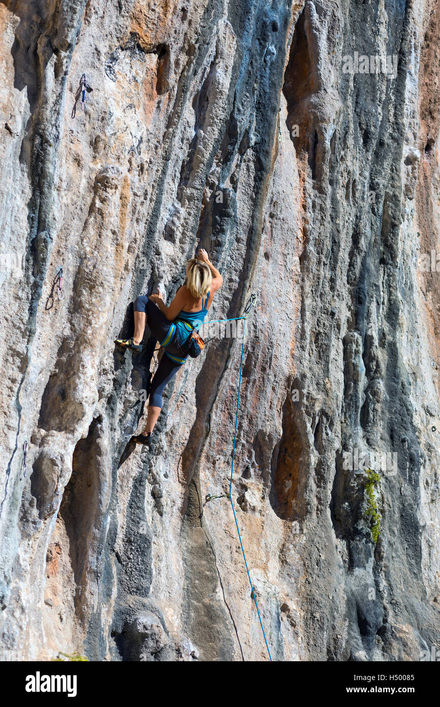 Young Rock Climber ascending steep colorful rocky Wall Lead Climbing ...