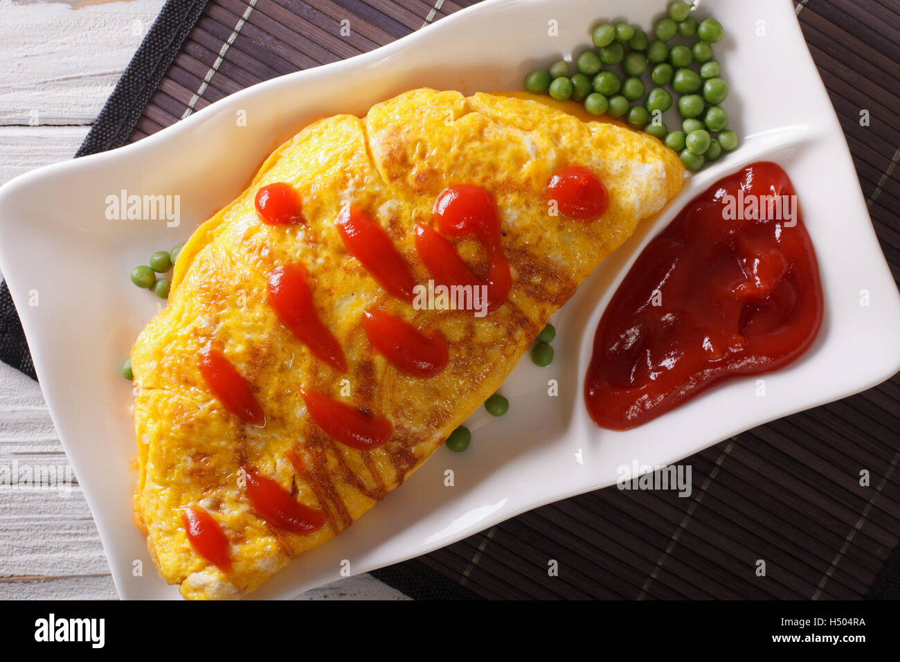 Japanese omelet stuffed with rice and chicken close-up on a plate ...