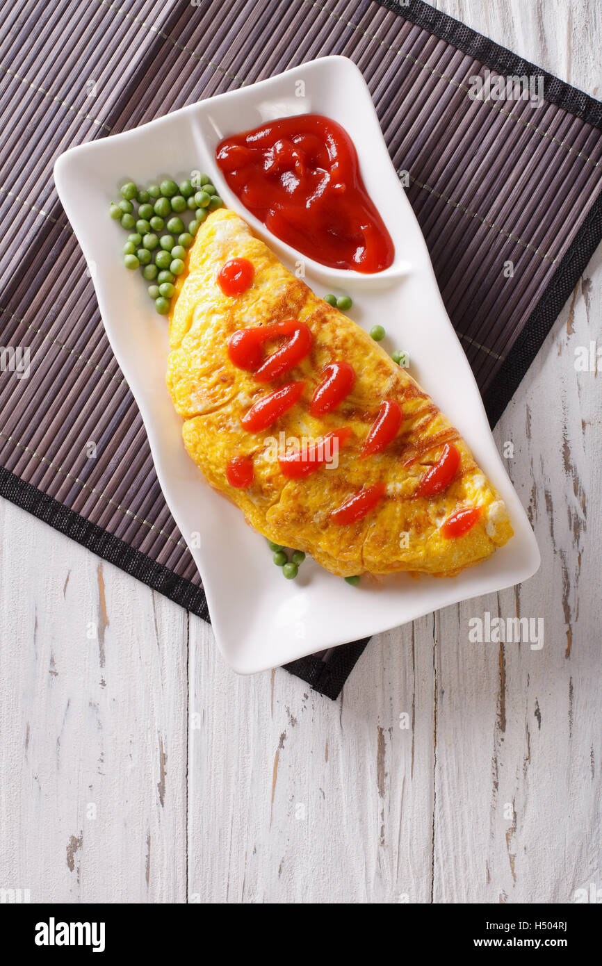 Japanese Omurice omelet stuffed with rice and chicken on a plate ...
