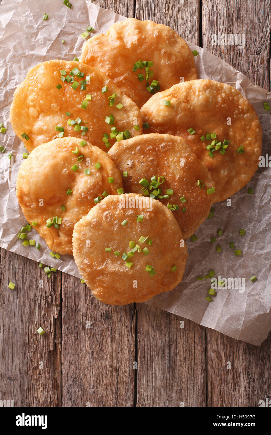 Indian Cuisine: Puri close-up paper on the table. Vertical top view ...
