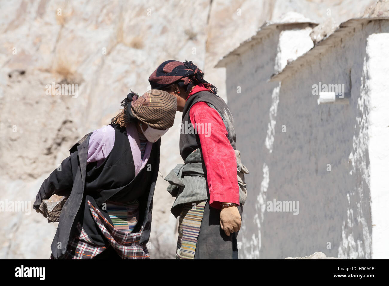 Two women carrying large stones to build a new home, Old Lhatse, Tibet ...