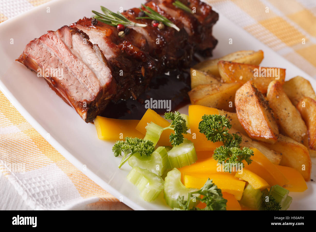 BBQ pork ribs with salad and fried potatoes on a plate close-up ...