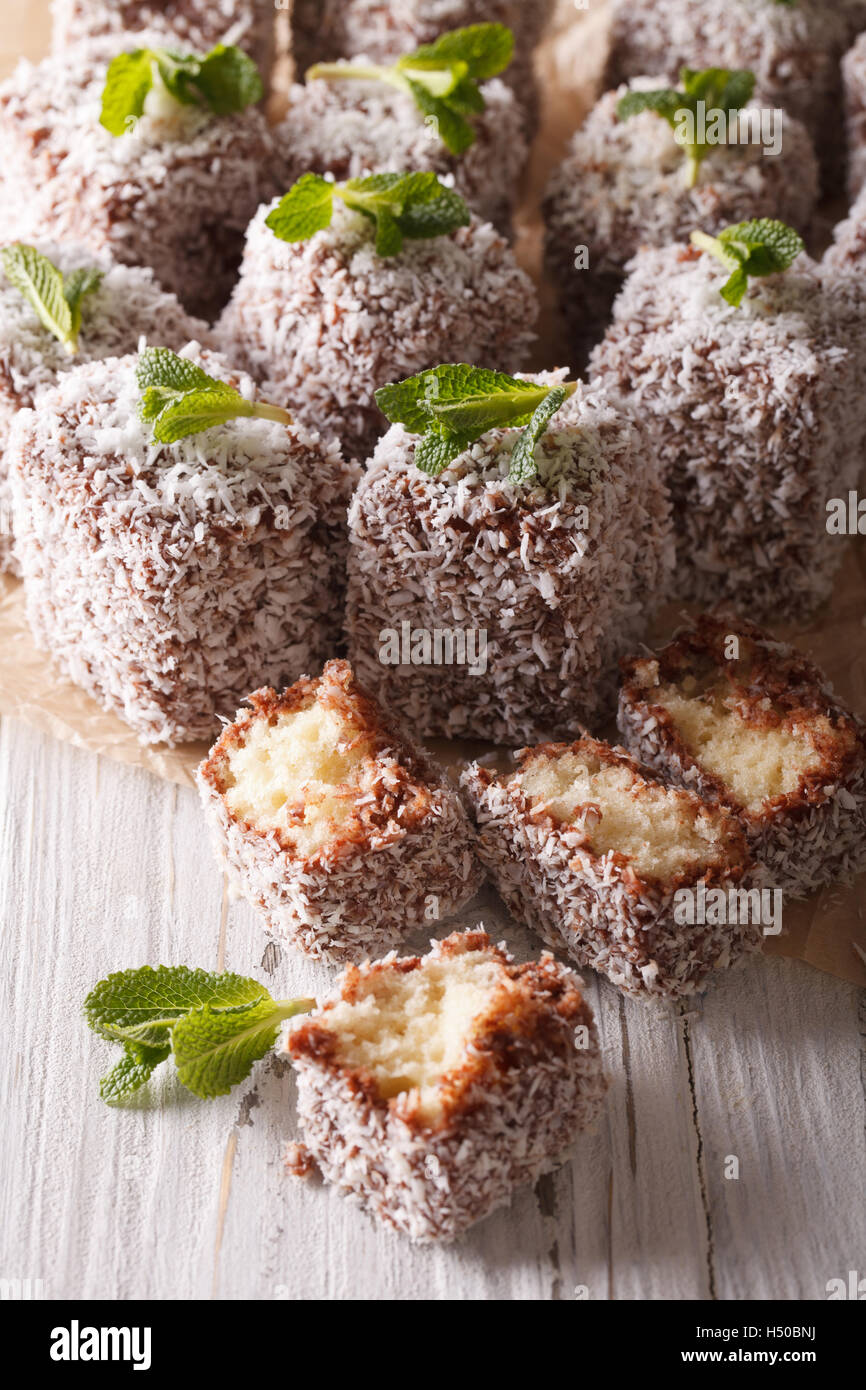 Sponge cake decorated with coconut close-up on the table. vertical ...