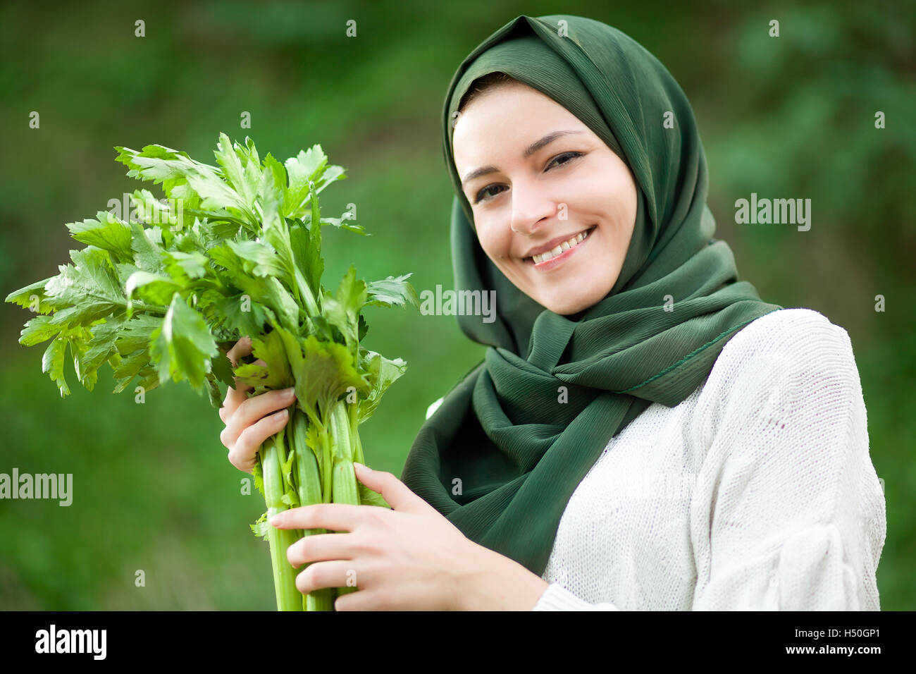 Muslim Vegan Woman with Veil Holding a Celery Stock Photo - Alamy