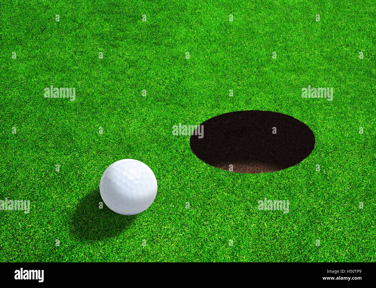 Golf ball close to hole with copy space Stock Photo - Alamy