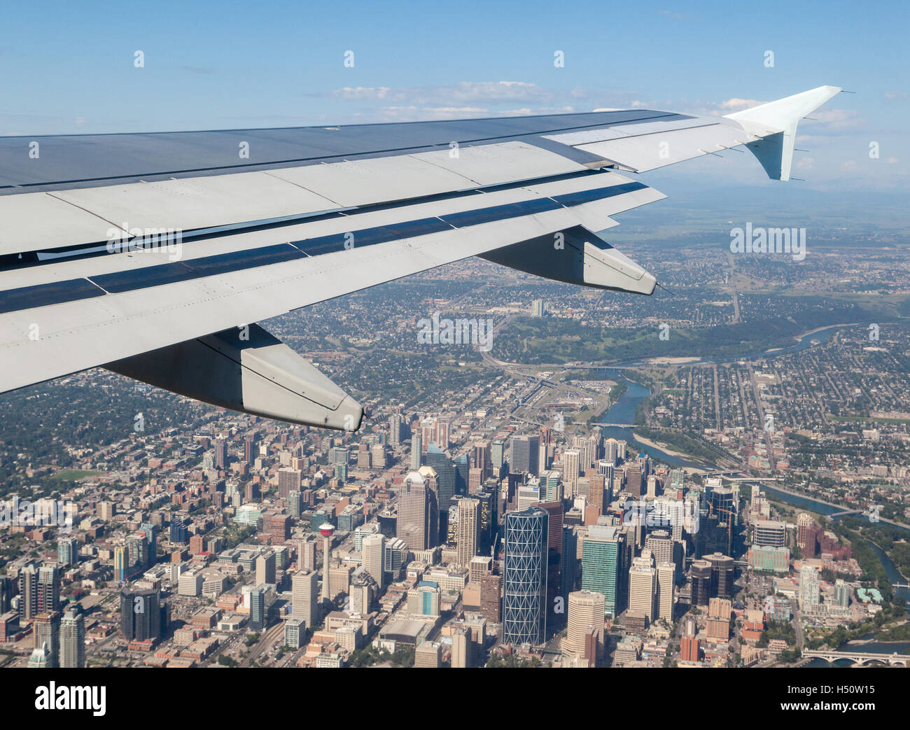 Airplane window view showing wing of the plane flying over downtown ...