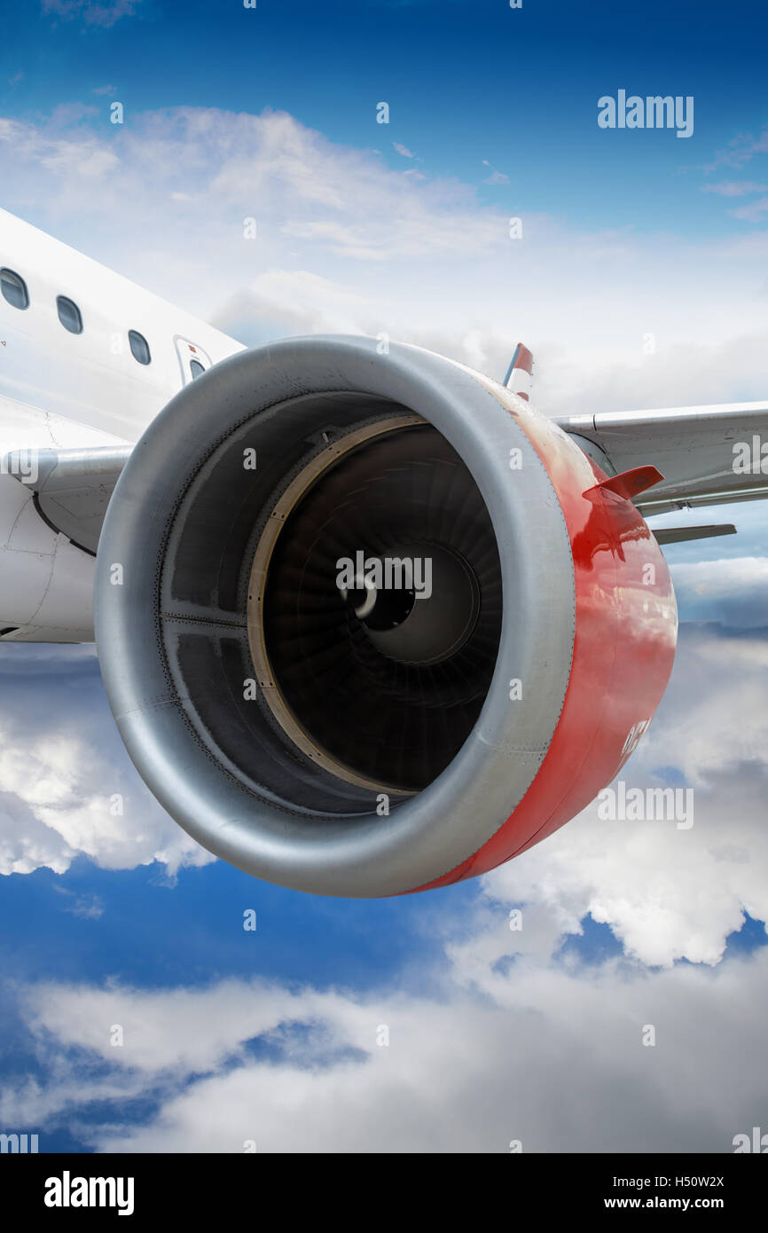 Commercial airplane with red engine in flight through clouds. Realistic ...