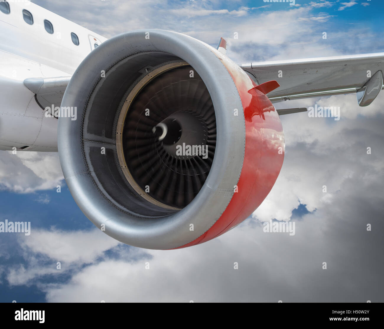 Commercial airplane with red engine in flight through clouds. Realistic ...