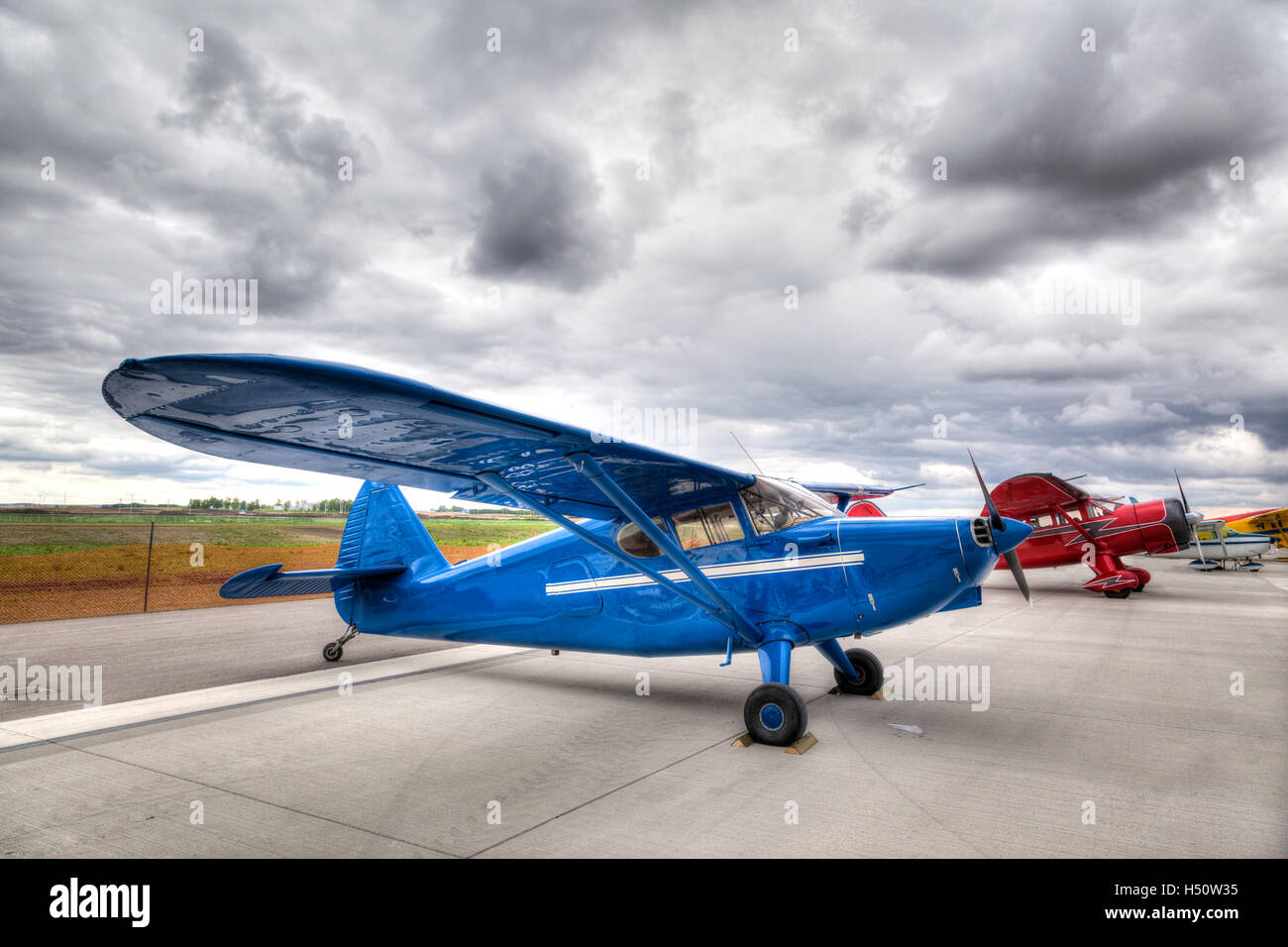 Small vintage single propeller airplanes parked on an airport tarmac ...