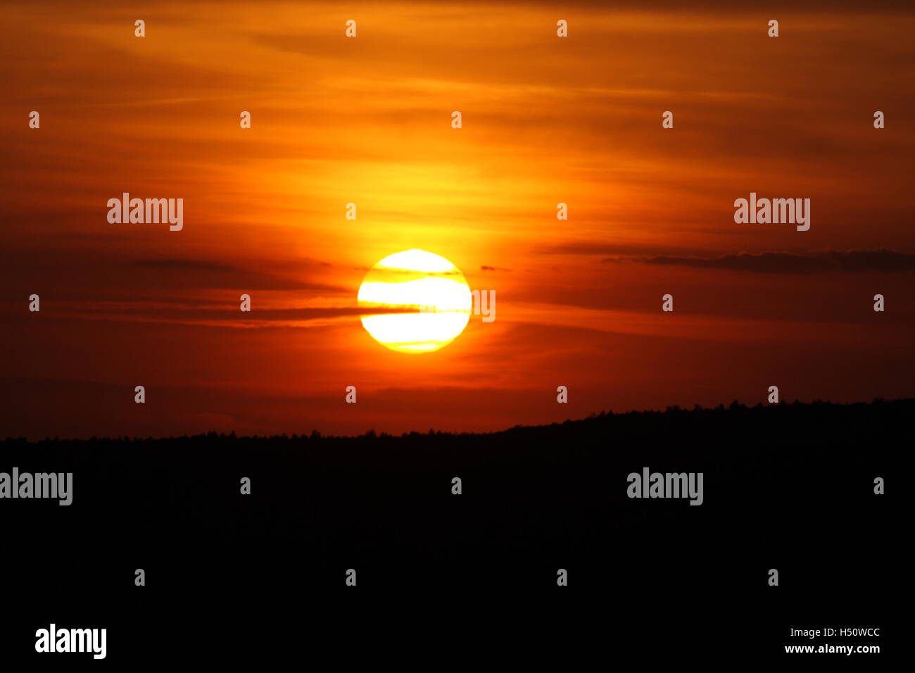 sunset photo of a large orange sun Stock Photo - Alamy