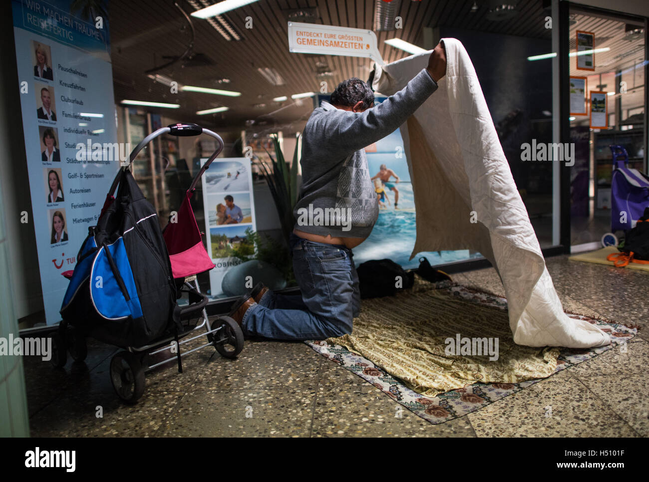 A homeless person spreads a blanket on the ground in Frankfurt am Main ...