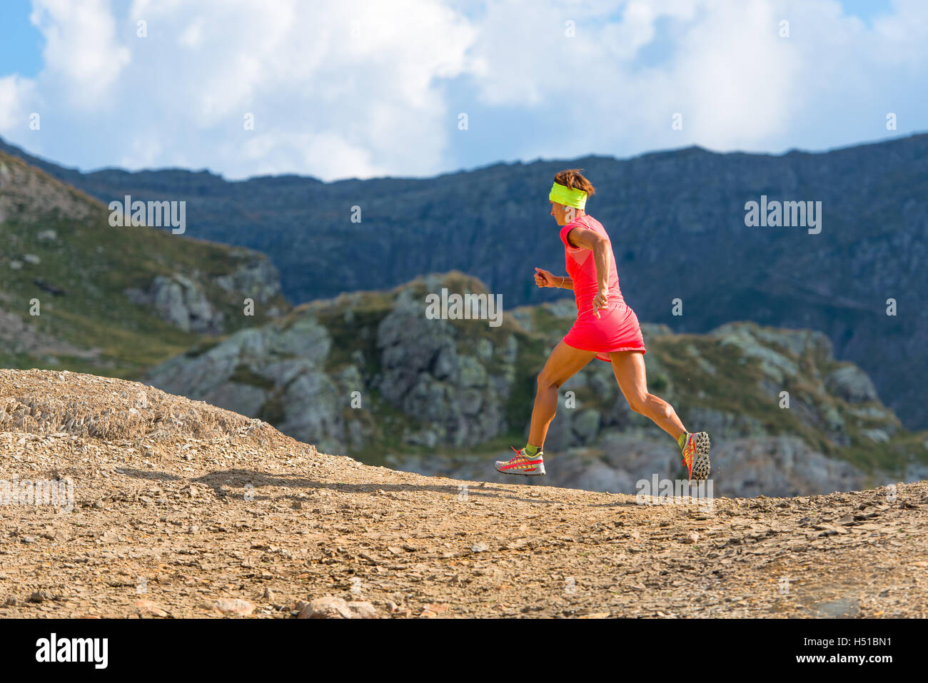 Female athlete runs in the mountains practice skyrunning with ...