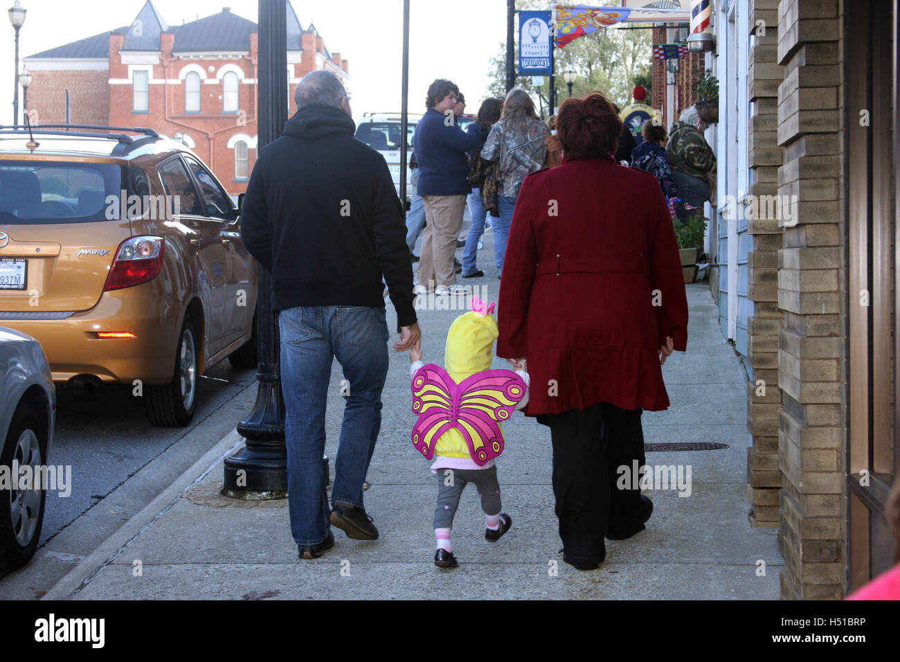 Little child going trick-or-treating on Halloween with grandparents ...