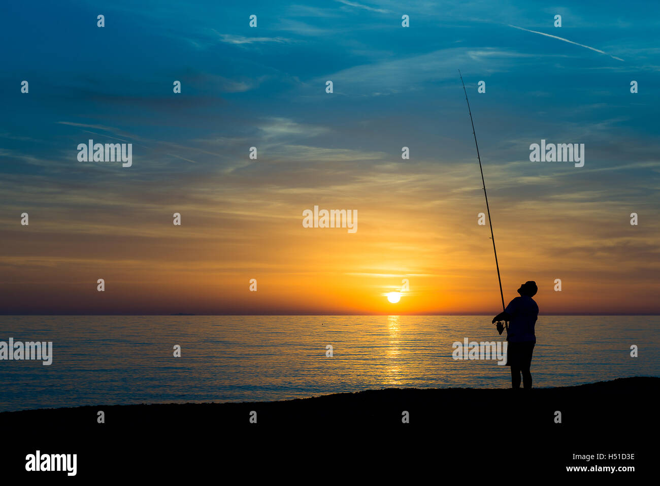 Fisherman on the beach at sunset Stock Photo - Alamy