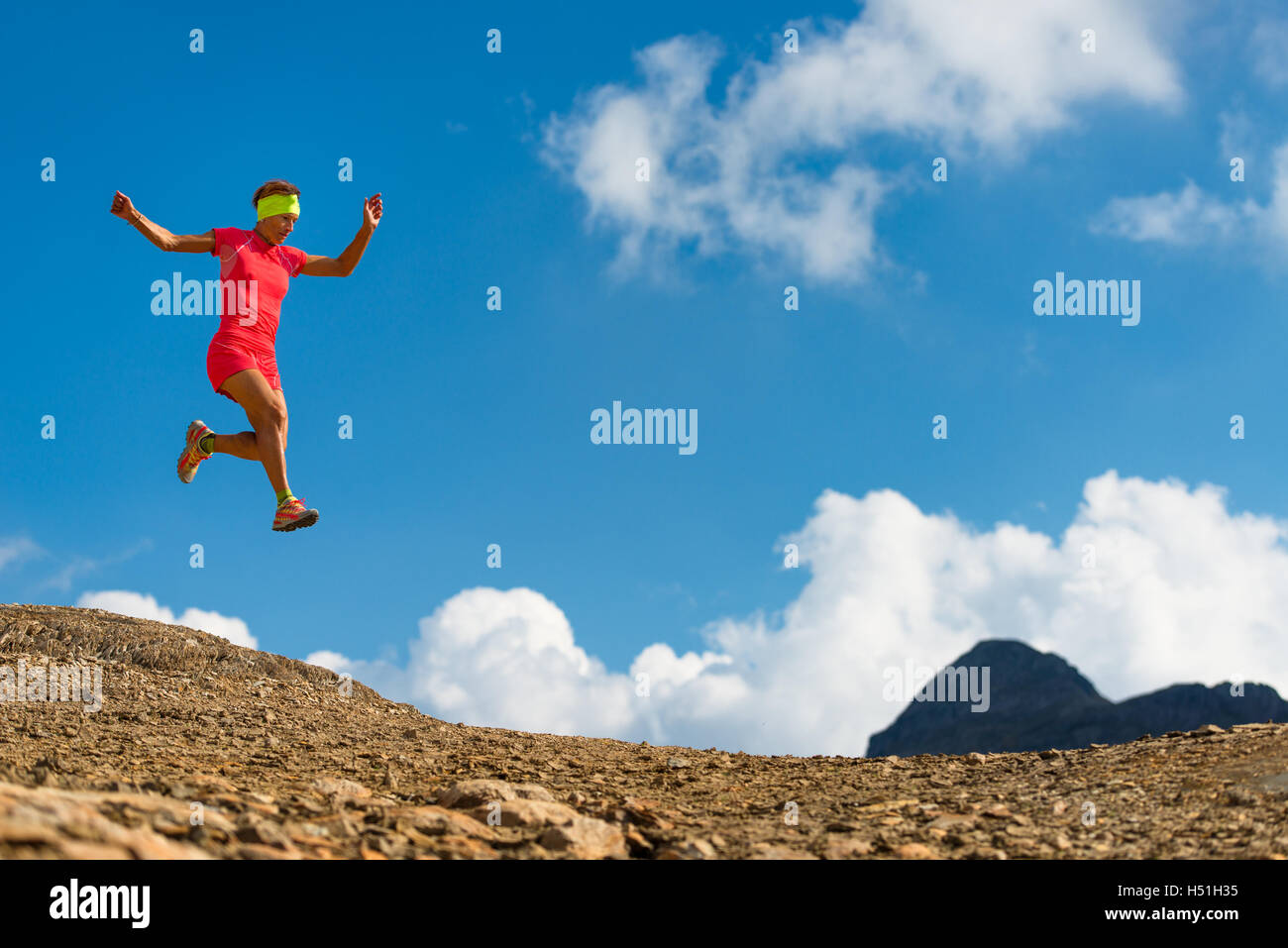 Girl makes a jump while running in the mountains Stock Photo - Alamy