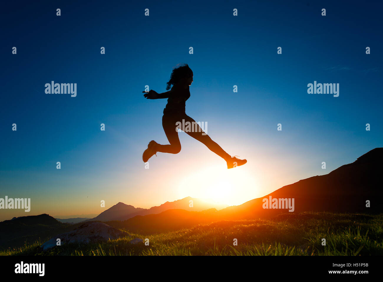 Girl jumps during a sunset in the mountains Stock Photo - Alamy