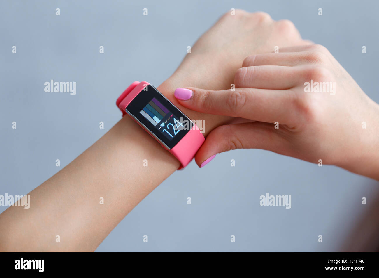 Isolated female hand with pink smartwatch taking pulse after exercising ...