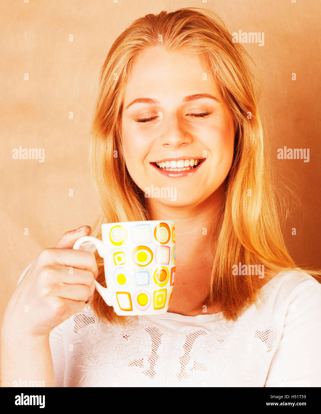 young cute blond girl drinking coffee close up on warm brown bac Stock ...