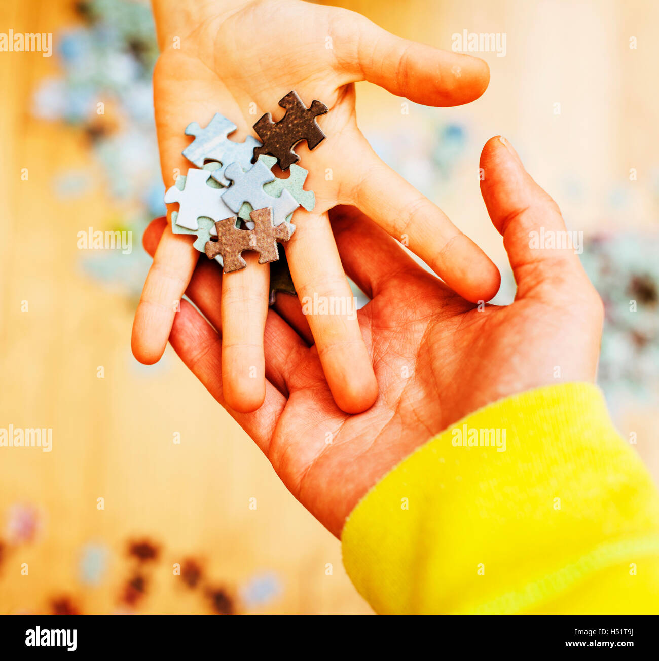 little kid playing with puzzles on wooden floor together with pa Stock ...