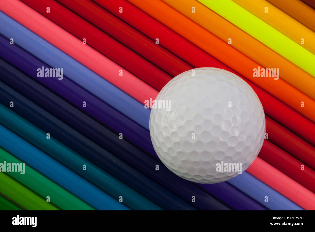 Detail of rainbow colorful pencil and golf ball on the table Stock ...