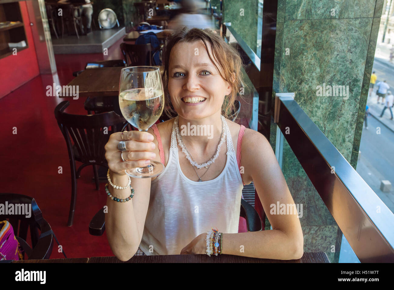 Woman with glass of wine doing cheers Stock Photo - Alamy