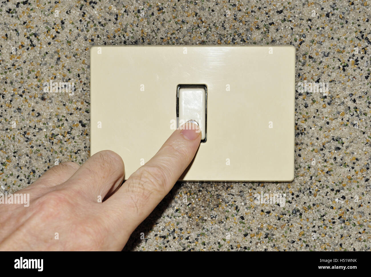 pressing a wall mounted light switch Stock Photo - Alamy