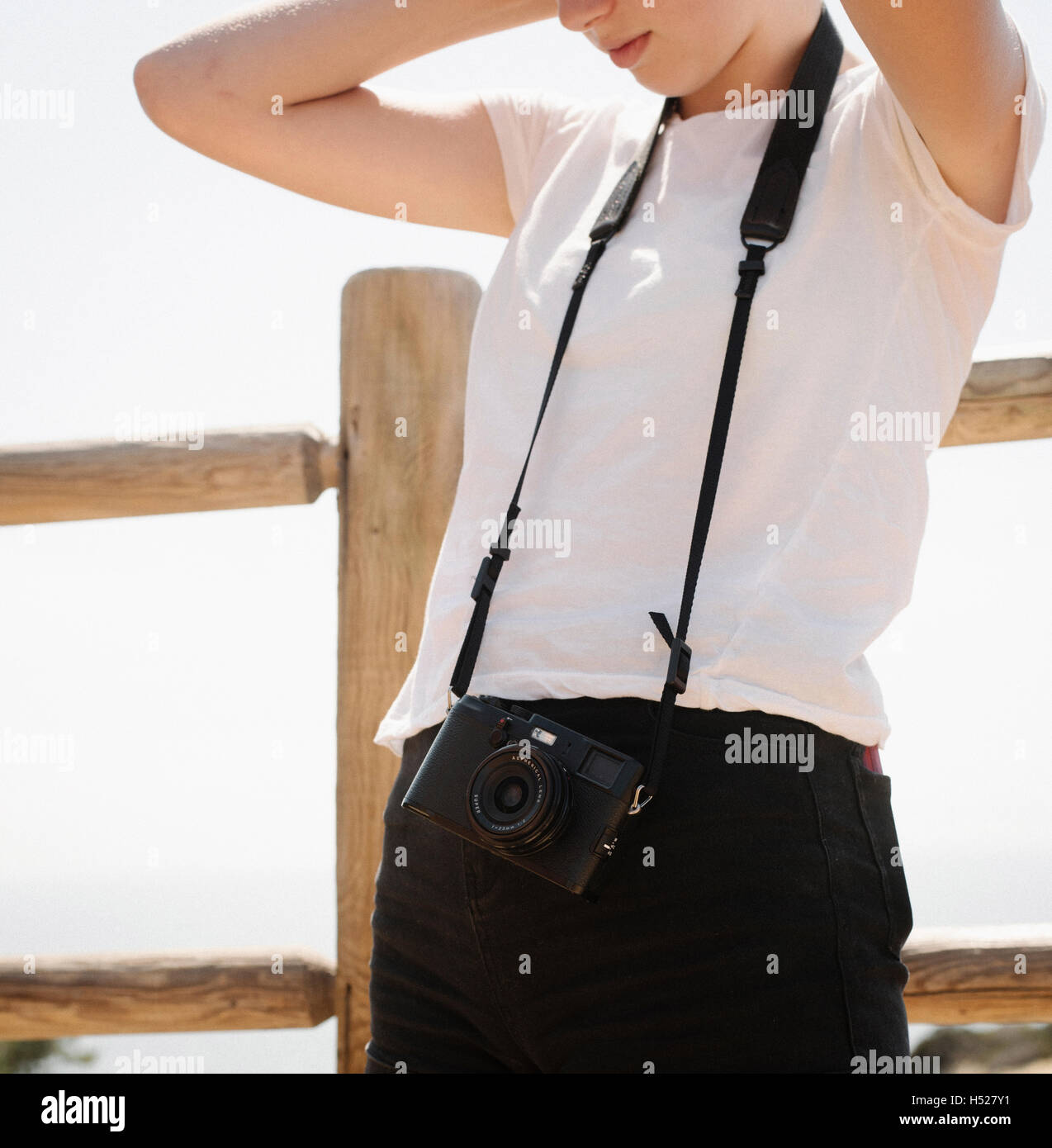 Teenage girl at a wooden fence, a camera round her neck Stock Photo - Alamy