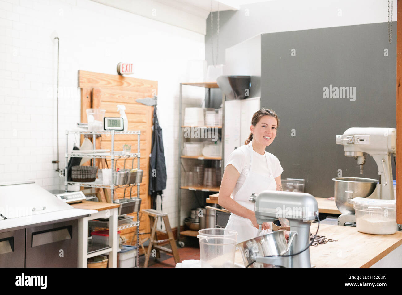 Woman wearing a white apron at a work counter in a bakery Stock Photo ...