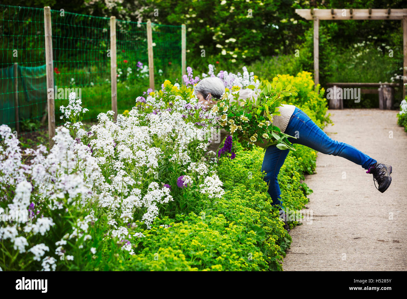 A florist selecting flowers and plants from the garden to create ...