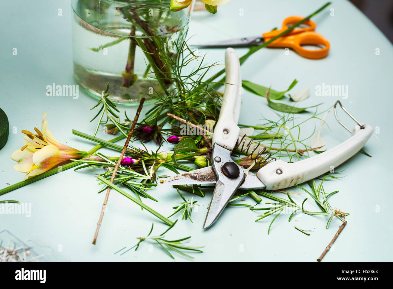 Flower arranger's workbench. Secateurs, scissors and plant stalks and ...
