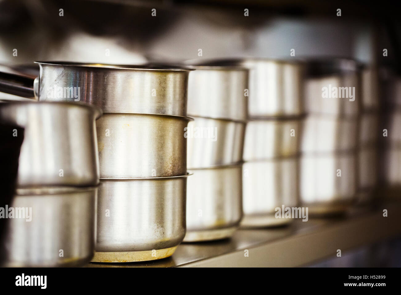 Close up of a stack of stainless steel pots in a restaurant kitchen ...