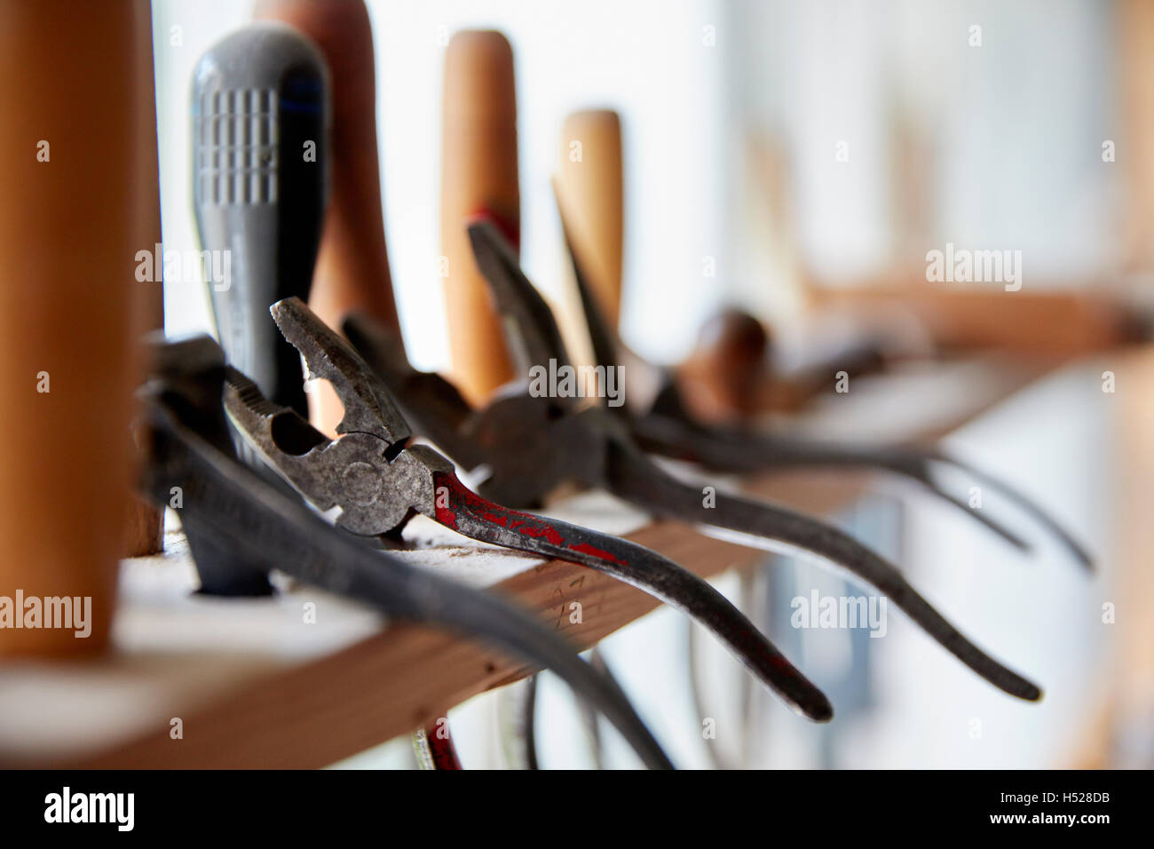A violin maker's workshop. A rack of hand tools along the window Stock ...