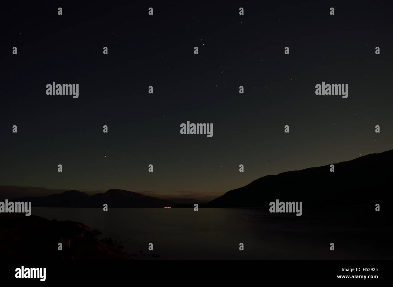 fjord and mountain landscape in late autumn night with star filled sky ...