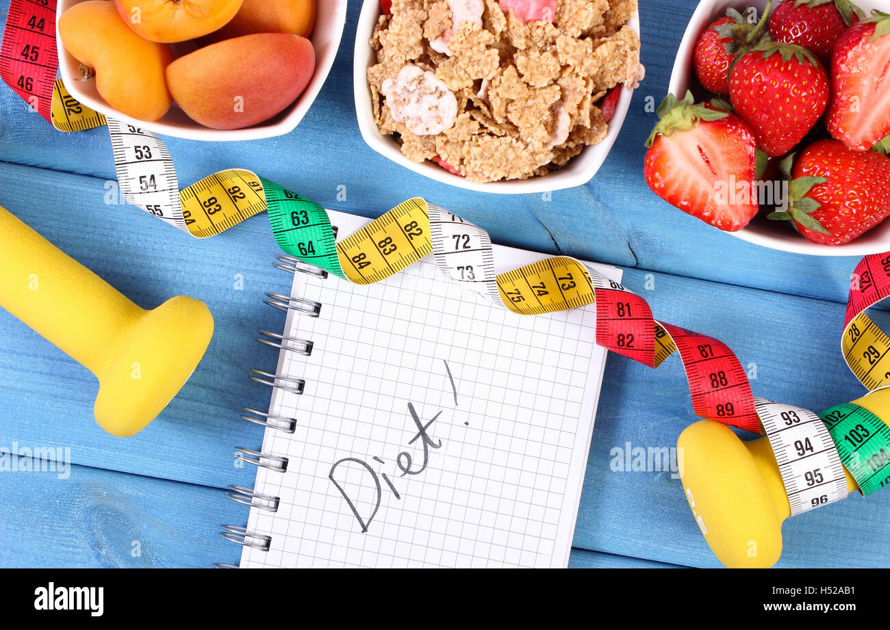 Fresh healthy food, dumbbells for fitness, tape measure and notebook ...